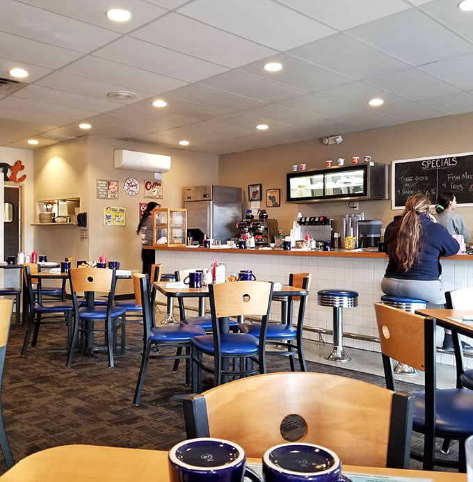 The counter seating&mdash;where solo diners become part of the Mayberry family. Those blue mugs promise infinite coffee and finite problems.