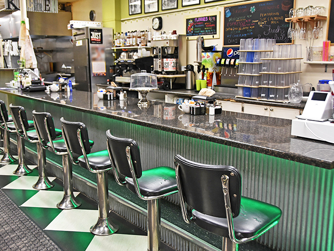 Classic diner counter seating where coffee refills appear like magic and the staff remembers how you like your eggs after just one visit.