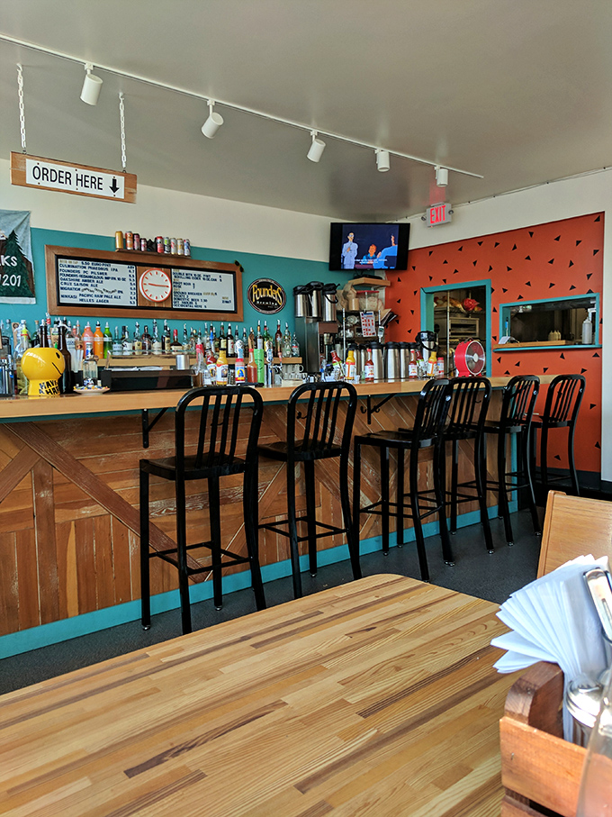 The bar area whispers, "Stay awhile," with its warm wood tones and rainbow of bottles promising libations to complement your plant-based feast.