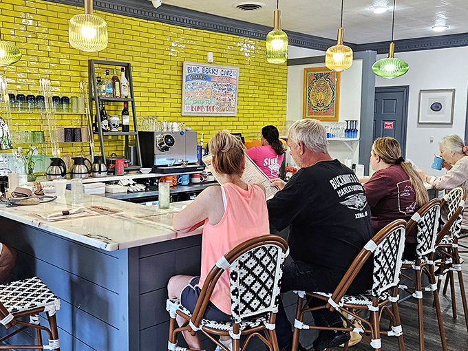 The counter seats &ndash; where breakfast aficionados watch the magic happen. That vibrant yellow brick wall adds sunshine even on cloudy mornings.