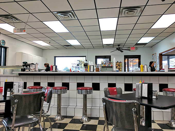 Counter seating: where solo diners become regulars and regulars become family. The black and white tile pattern extends the 50s chess match.