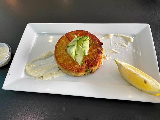 The legendary crab cake&mdash;more crab than cake&mdash;sitting proudly on its plate like it knows it's the reason you drove across town. That subtle drizzle of sauce? Just showing off.