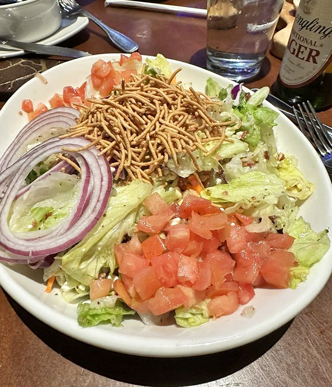 Even the dinner salad gets special treatment here, topped with crispy noodles and fresh vegetables.