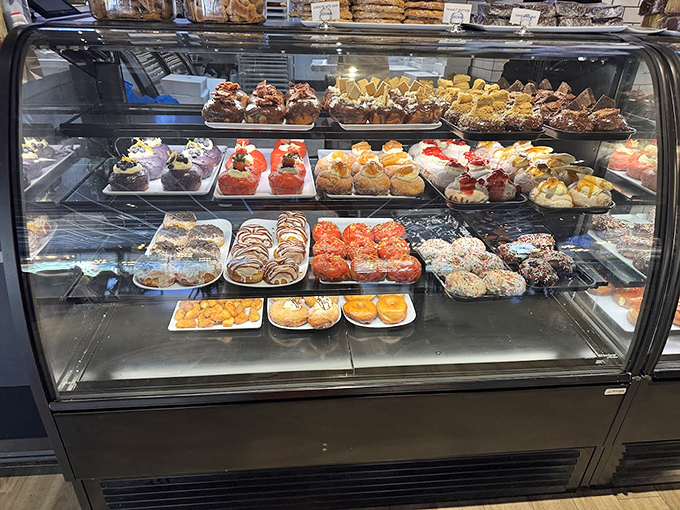 The display case of temptation where willpower goes to die. Each colorful creation is a handcrafted argument against skipping breakfast or counting calories.