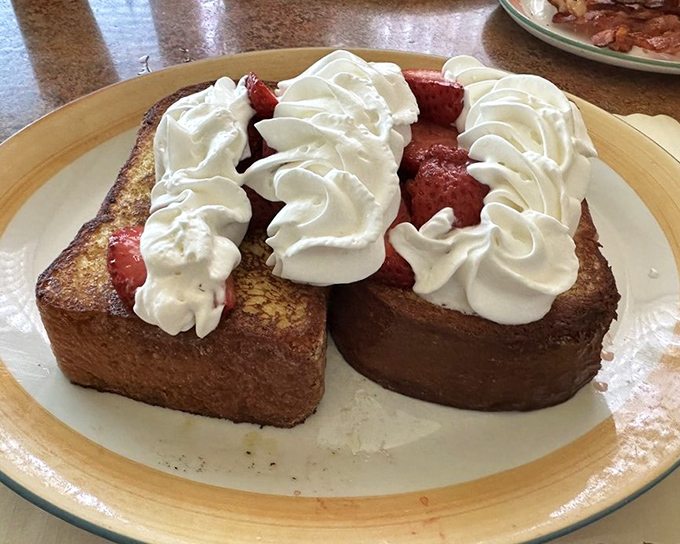 French toast that's practically dessert for breakfast, with strawberries and whipped cream creating a morning celebration on your plate.