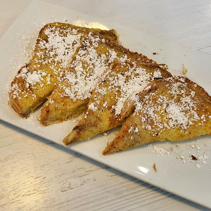 French toast transformed into something magical. Golden triangles dusted with powdered sugar that would make breakfast skeptics into morning meal converts.