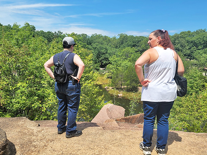 Two visitors pause to take in the sweeping vista, experiencing that rare moment when nature stops you in your tracks and demands appreciation.