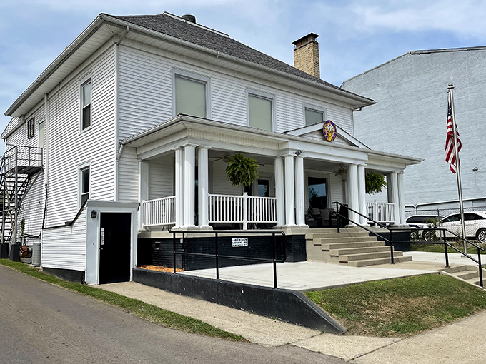 The Elks Lodge presents itself with classic white columns and American flag, like a community living room where important decisions and potluck dinners happen with equal ceremony.
