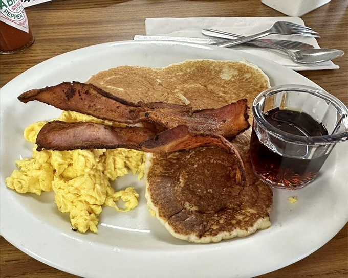 The breakfast trinity: Perfectly scrambled eggs, bacon with that ideal bend-don't-break texture, and pancakes that could convert a breakfast skeptic into a morning person.