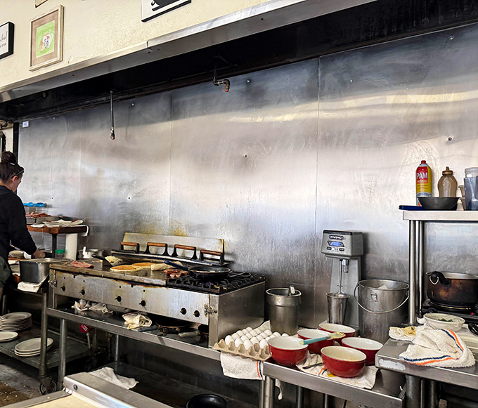 Behind-the-scenes glimpse of where culinary breakfast miracles happen with practiced precision and care.