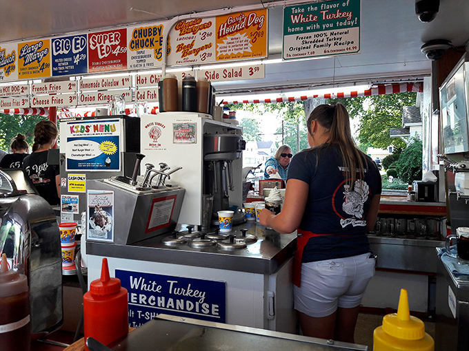 The kitchen view reveals the beautiful ballet of short-order cooking. Every movement purposeful, every sandwich assembled with the care usually reserved for fine art.