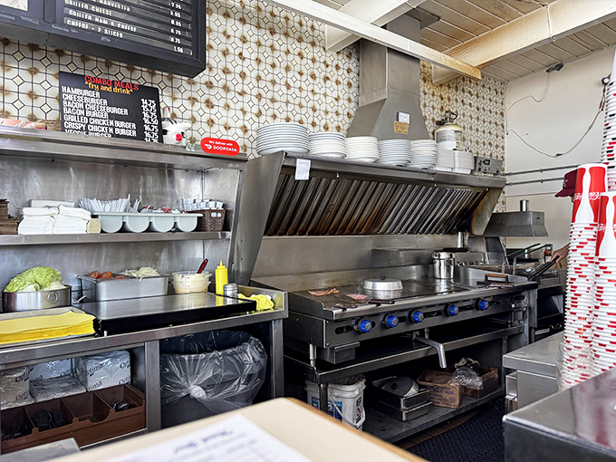 The open kitchen reveals the battlefield where burger magic happens&mdash;stainless steel, sizzling grills, and organized chaos.