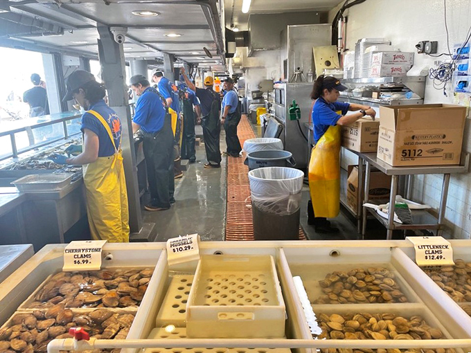 The assembly line of deliciousness. Blue-uniformed seafood soldiers prepare the day's catch while clams and mussels await their culinary destiny.