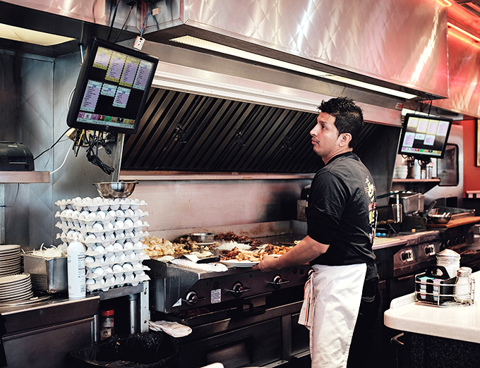The kitchen ballet in full swing&mdash;where short-order magic happens amid stacks of eggs and sizzling grills.