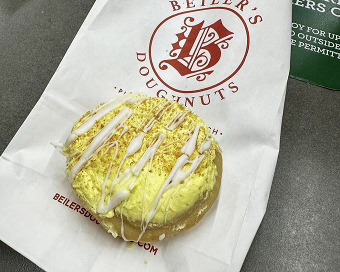 This sunshine-yellow lemon donut promises a perfect balance of sweet and tart. The white drizzle adds both visual appeal and extra sweetness.