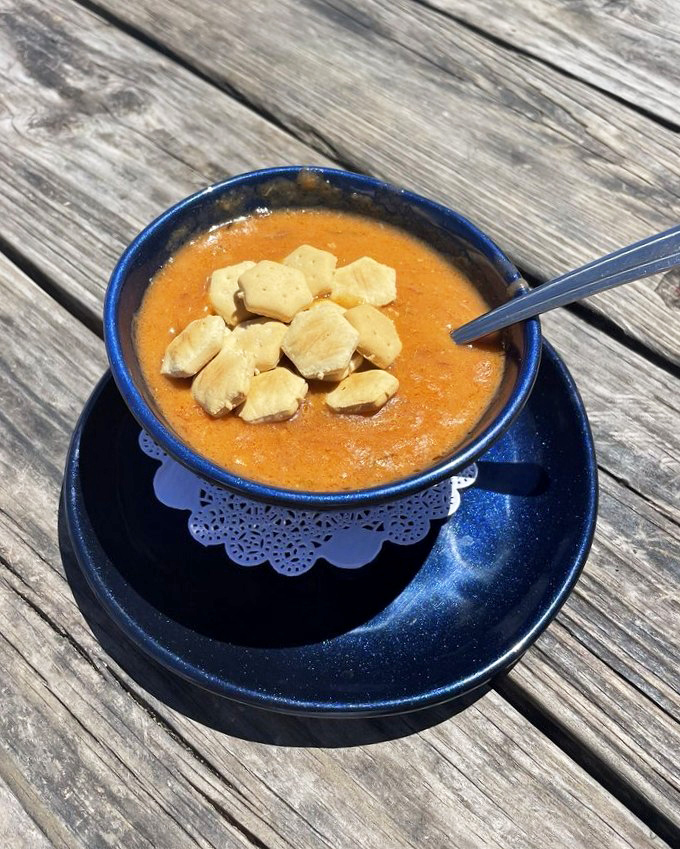 A sunset captured in soup form. This lobster bisque, topped with oyster crackers, delivers oceanic richness that would make Neptune himself request seconds.
