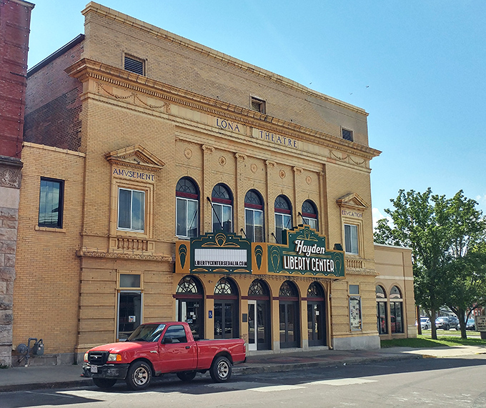 The Lona Theatre's golden facade promises entertainment magic – the Netflix of its day, but with better architecture.