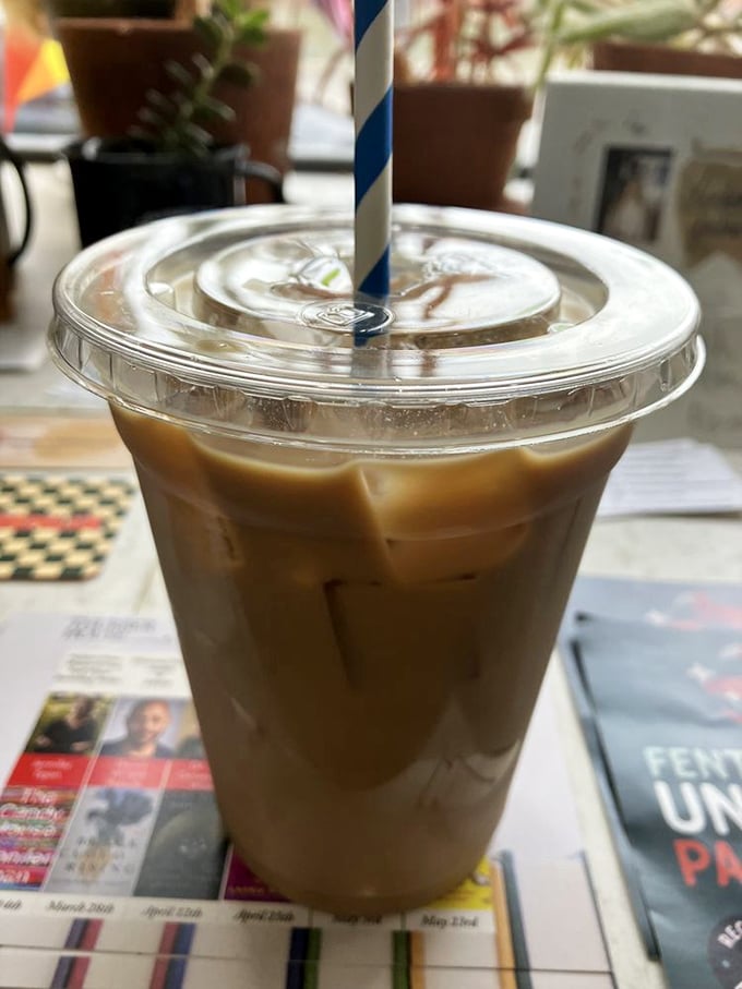 Iced coffee served with a jaunty blue straw&mdash;the caffeinated sidekick to your pastry adventure. Newspaper optional, daydreaming mandatory.