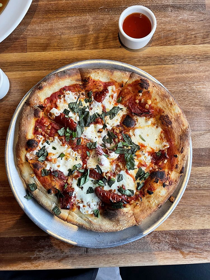A pizza that respects the Italian tradition while giving a knowing nod to California's obsession with fresh ingredients. Those basil leaves are practically waving hello.