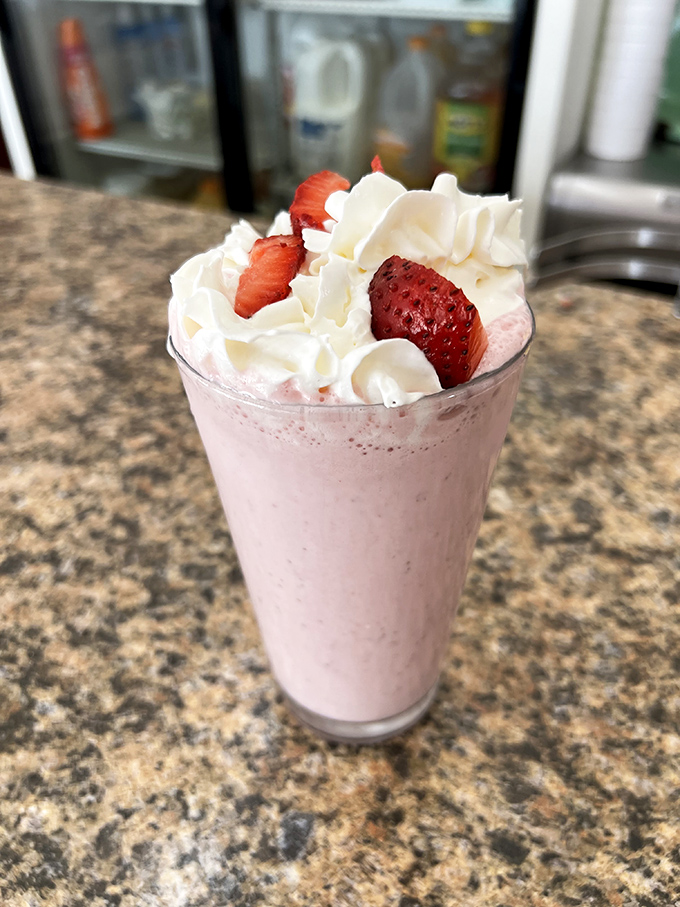 This strawberry milkshake isn't just a drink, it's a time machine back to simpler days when happiness came in a tall glass topped with whipped cream.