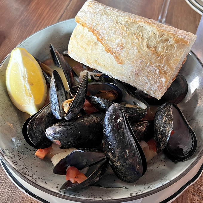 Mussels bathed in broth that begs to be sopped up with that crusty bread. A dish that transports you to coastal bliss with each tender bite.