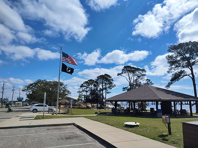 The community pavilion flies Old Glory alongside a local flag, offering shaded respite for community gatherings and impromptu picnics.
