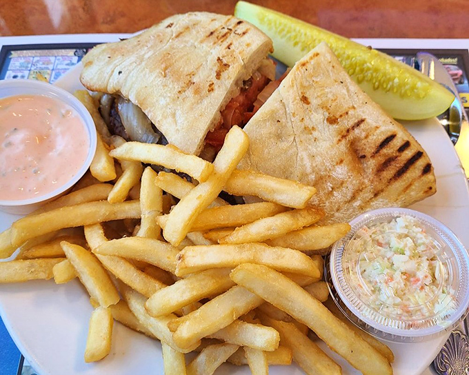 Not just a sandwich but an architectural achievement, this panini's grilled exterior gives way to a treasure trove of fillings, with fries and sauce as worthy companions.