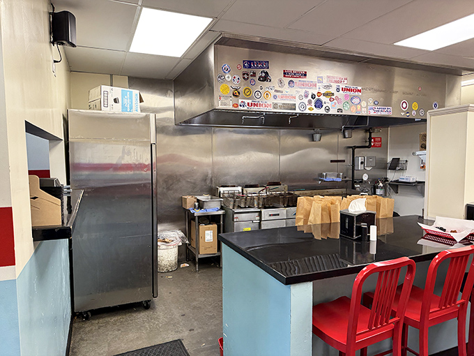 A glimpse into the kitchen reveals the sticker-adorned heart of the operation, where burger magic happens without smoke and mirrors&mdash;just fire and skill. 