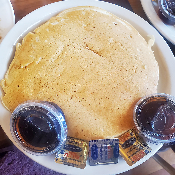 A pancake so perfectly golden it belongs in Fort Knox. Those butter packets are about to experience their glorious destiny.