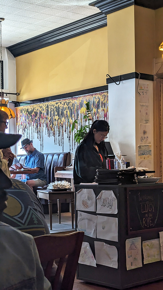 The host station, decorated with customer drawings, stands like a friendly gatekeeper to the promised land of breakfast delights beyond.