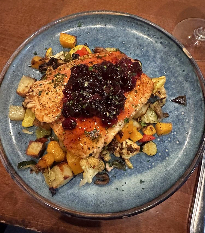 Salmon wearing a berry beret (Prince would approve) atop a colorful medley of roasted vegetables. The fish is perfectly cooked&mdash;flaky, tender, and ready for its close-up.