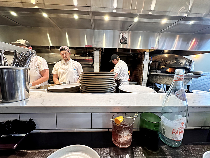 The open kitchen offers dinner and a show. These culinary choreographers move with the practiced precision of people who truly love what they do.