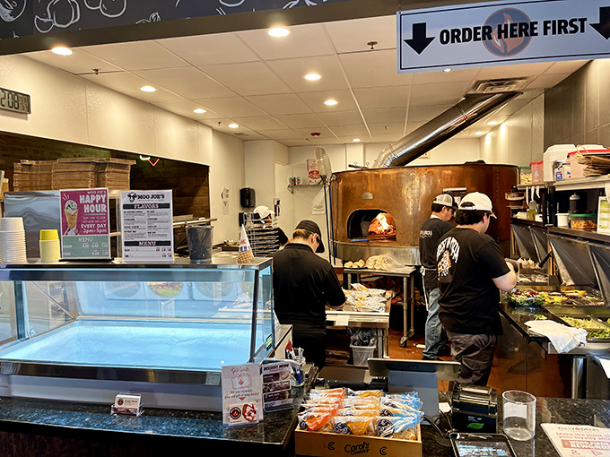 Behind the counter, pizza artisans move with the practiced efficiency of Broadway stagehands, turning dough into dinner right before your eyes.
