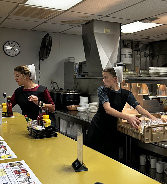 The kitchen staff works with practiced efficiency, their Amish caps a reminder of the authentic traditions behind every dish served.