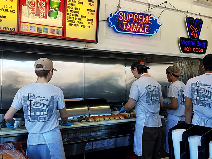 Behind the counter, a team of hot dog artisans works with the focused precision of symphony musicians during a sold-out performance.