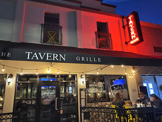 The Tavern Grille glows with evening promise as string lights twinkle overhead. Where locals and visitors alike toast to days well spent.