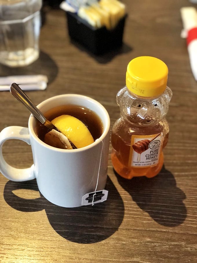 Hot tea served with honey in a bear bottle&mdash;because sometimes the simplest pleasures, like squeezing that little bear, bring the most joy.