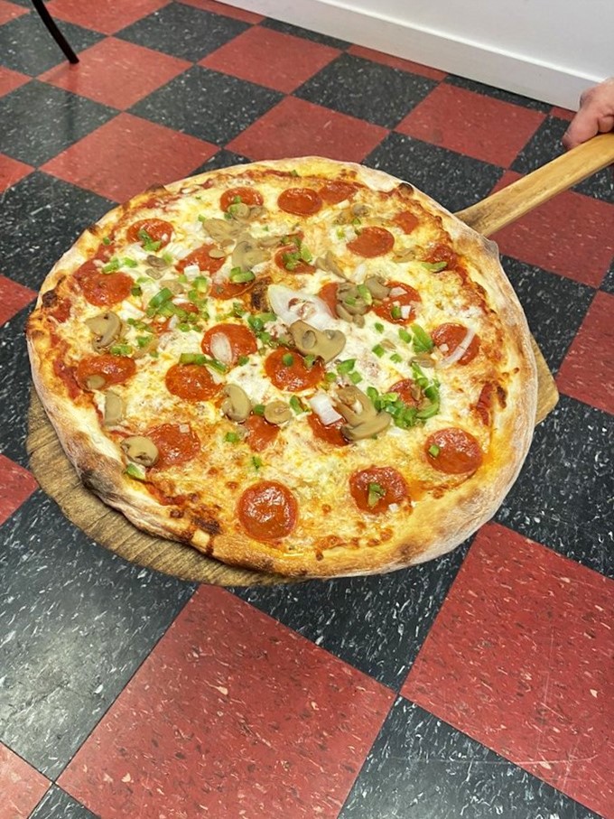 This isn't just pizza&mdash;it's a wooden-paddle-delivered masterpiece with toppings arranged like they're posing for their own Food Network special.