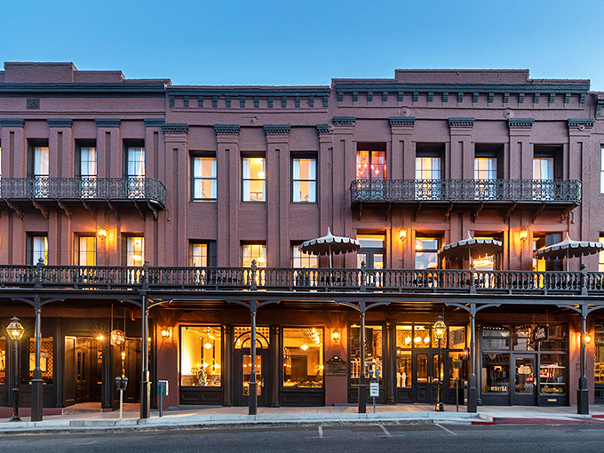 The National Exchange Hotel glows with Victorian splendor at dusk. Its warm lights invite you to step back in time while enjoying thoroughly modern comforts.