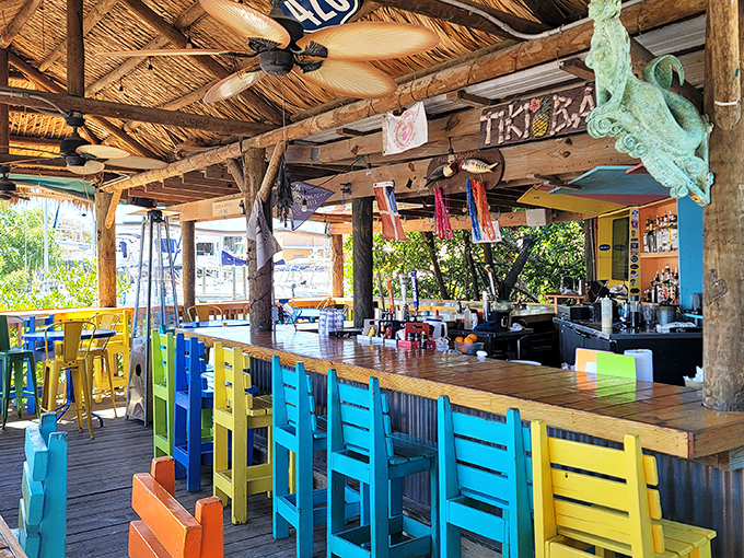 A tiki bar where time slows down and worries dissolve faster than ice in Florida sunshine. Those colorful chairs are therapy without the hourly rate.