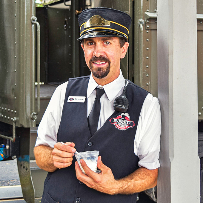 With a knowing smile and vintage uniform, this conductor isn't just checking tickets&mdash;he's your personal guide to railroad history.