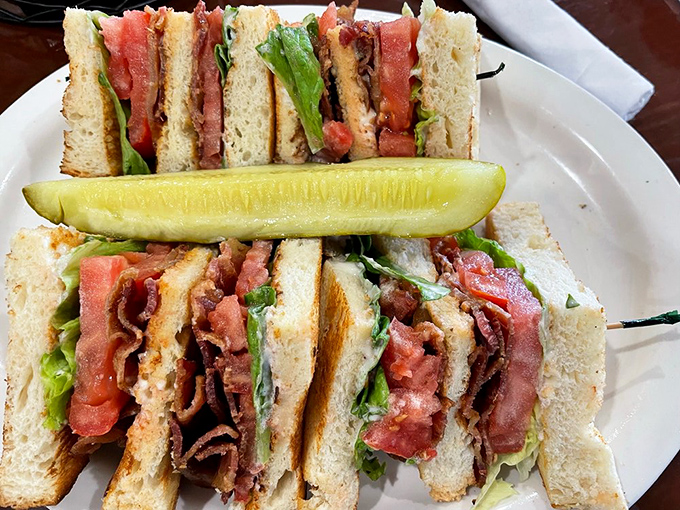 The club sandwich that makes other sandwiches feel underdressed. That pickle spear is the exclamation point on a multi-layered statement.