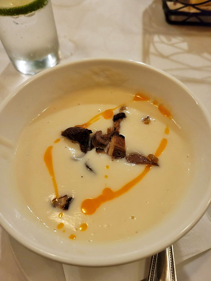 This isn't just soup&mdash;it's a silky canvas of turnip velout&eacute; with mushroom islands and a sunset drizzle of what must be chili oil.