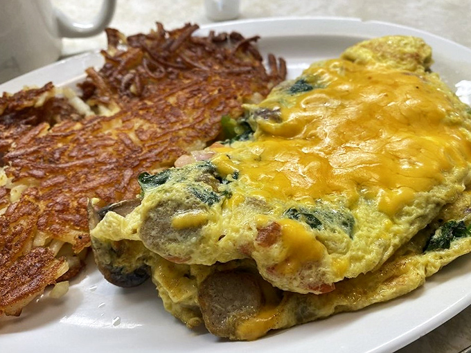 A veggie omelet that proves vegetables can party too, especially when paired with hash browns crisped to golden perfection.