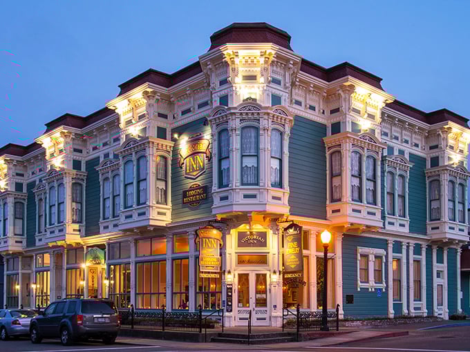 The Victorian Inn glows at twilight, its ornate corners illuminated like a wedding cake waiting for after-dinner guests.