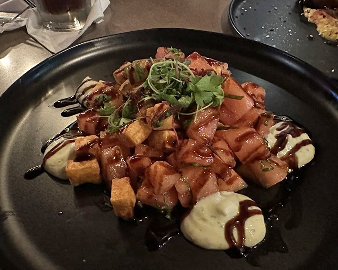 A dish that looks like it was plated by someone who really, really cares. Those sauces are playing a symphony on that black plate.