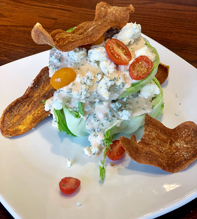 A wedge salad that's dressed better than most people at a fancy wedding, complete with blue cheese crumbles and crispy accessories.