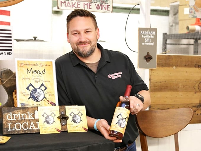 Make Me Wine isn't just a sign&mdash;it's a life philosophy for this mead vendor, whose smile suggests he's found the secret to turning honey into liquid joy.