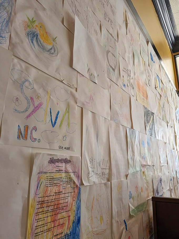 A wall of children's artwork transforms the space into a community gallery, showcasing the restaurant's heart and connection to local families.