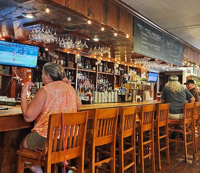 A well-stocked bar where glasses hang like crystal stalactites, ready to capture whatever libation might help you digest all that prime rib.